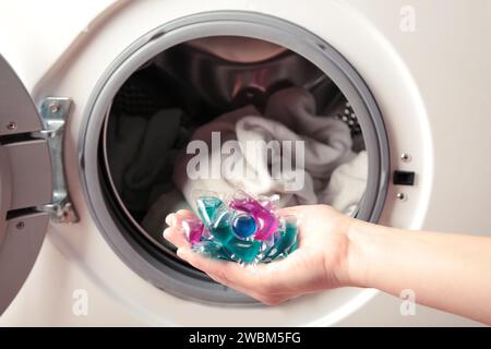 Hand holding gel caps for washing machine. Household laundry equipment ...