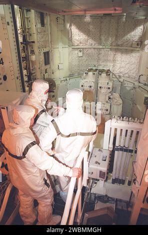 Members of the STS-100 crew look over the mission payload recently ...