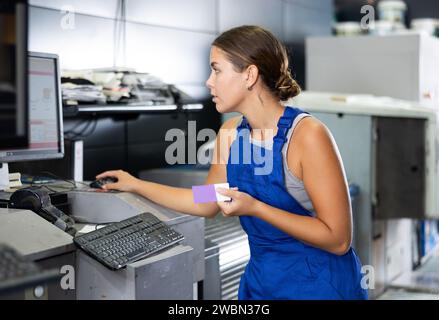 Warehouse girl employee look at computer monitor screen and check ...