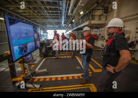 Crew members monitor equipment in the control room aboard the nuclear ...