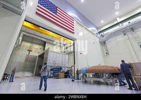 Technicians move the Orion heat shield for Artemis I toward the thermal ...