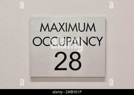Maximum Occupancy sign on a white interior wall in a commercial ...