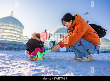 Parents and children play with the snow and ice in Jiangbin Park, Jilin ...