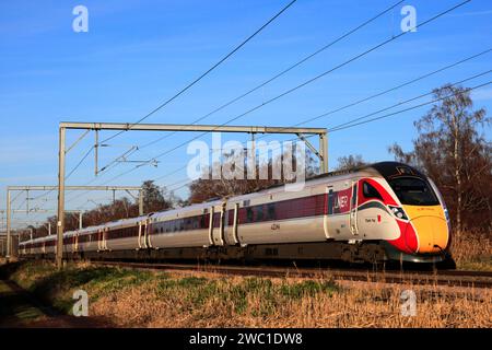 LNER, Azuma 801 class train passing Offord Cluny village, East Coast Main Line Railway ...