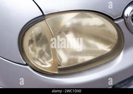 Hazy opaque yellowed front head lamp of car reduces light pass-through ...
