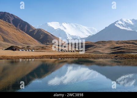 Yurts, mountains reflected in a small mountain lake, Pik Lenin, Trans ...