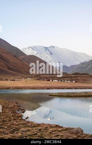 Yurts, mountains reflected in a small mountain lake, Pik Lenin, Trans ...