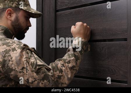Military commissariat representative knocking on wooden door Stock ...