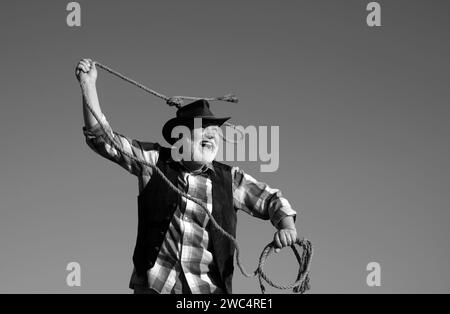 Senior western cowboy throwing lasso rope. Bearded wild west man with ...
