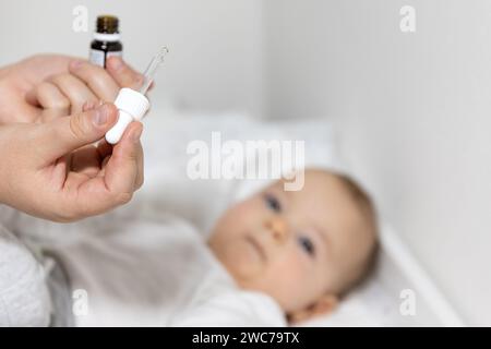 Mom giving vitamin D3 to newborn baby for care of the proper ...