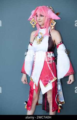 A Female cosplayer in a pink anime costume wearing pink hair Stock ...