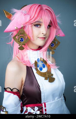 A Female cosplayer in a pink anime costume wearing pink hair Stock ...