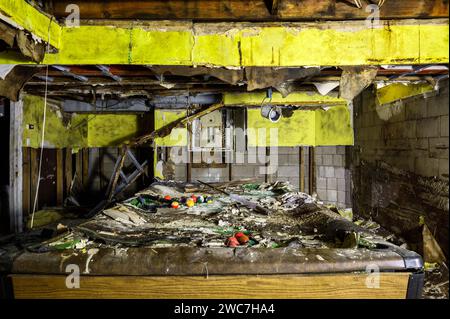 A pool table inside a moldy and decaying basement inside an abandoned ...