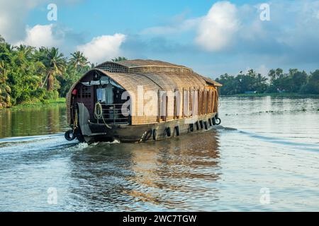 Indian traditional houseboats floating on Pamba river, with palms at ...