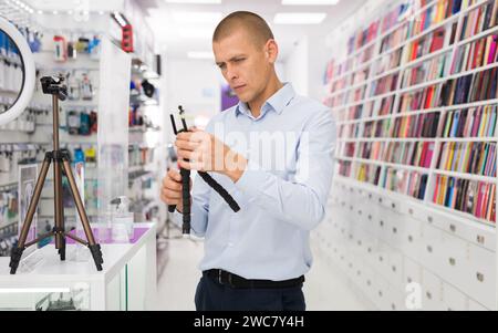 Male customer buying tripod at the multimedia store Stock Photo - Alamy
