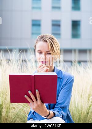 Pretty, young female student in front of a blackboard during class ...