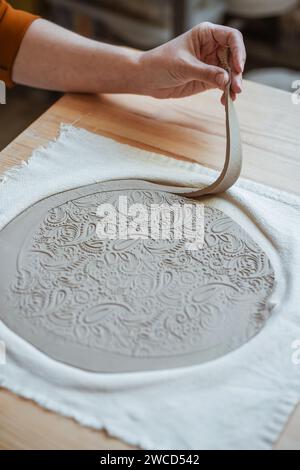 Hand modelling of openwork clay plate, pottery Stock Photo - Alamy