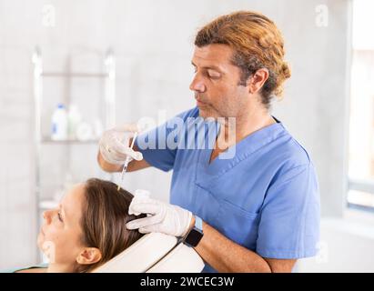 Woman applying scalp injection treatments by male doctor Stock Photo ...
