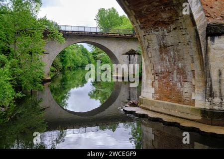 Vintage arched rail bridge, as it crosses the Thoré river, just outside ...