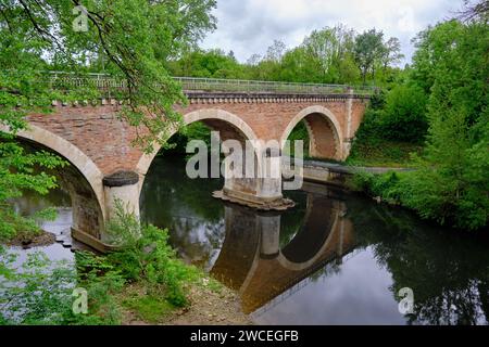 Vintage arched rail bridge, as it crosses the Thoré river, just outside ...