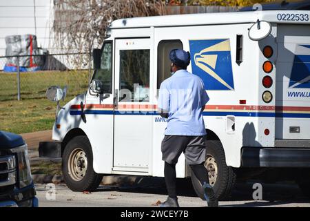 A United States Mailman walking toward his mail truck on a sunny day ...