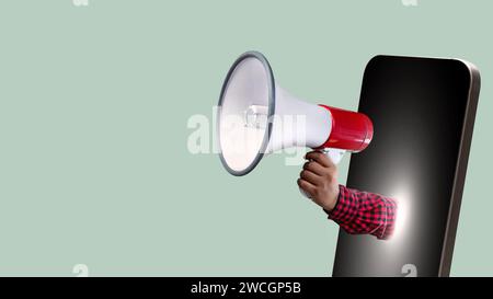 A human hand holding a megaphone comes out from the torn paper. Live ...