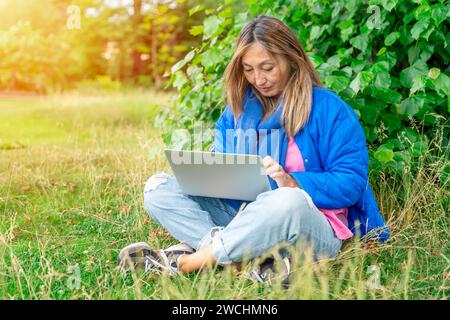 Asian Woman in blue jacket and protective mask looking out of train ...