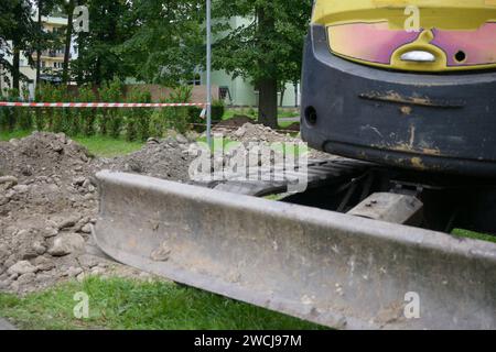 Mini excavator digging pits for optical cable Stock Photo - Alamy