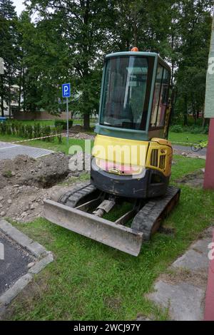 Mini excavator digging pits for optical cable Stock Photo - Alamy
