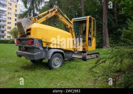 Mini excavator digging pits for optical cable Stock Photo - Alamy