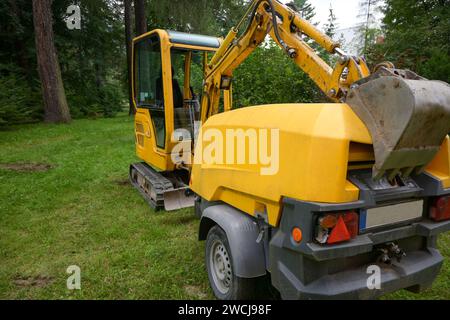 Mini excavator digging pits for optical cable Stock Photo - Alamy