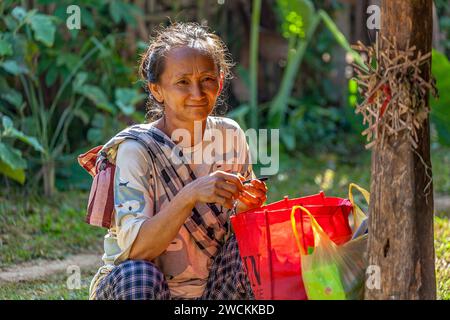 Lao woman of the Khmu / Khamu / Kemu tribe in front of bamboo hut in ...
