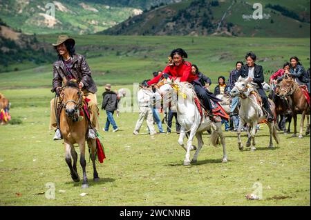 Tibet, Kham, Litang. Nomad men compete at a horse festival. Editorial ...