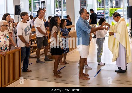 Priest giving communion at Mary Help of Christians Catholic Church, Ko ...