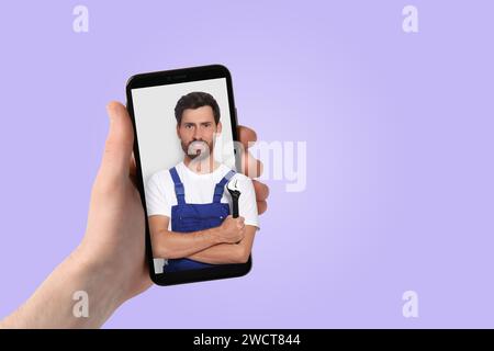 Find plumber. Man using mobile phone on light yellow background ...