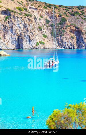 People paddleboarding on the emerald waters of Cala Mitjana, Menorca ...
