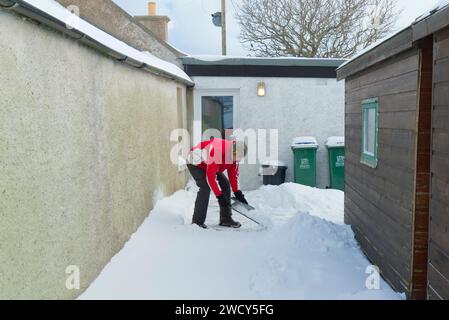Clearing snow from path behind house, Orkney, January 2024 Stock Photo ...