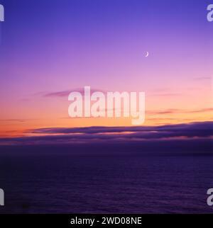 Crescent moon rising over pacific ocean near Yaquina Head; Oregon; USA ...