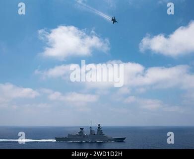 The French Navy frigate FS Chevalier Paul sails alongside USS George H.W. Bush as an F/A-18E ...