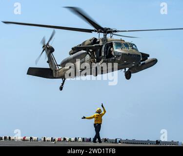 US Navy A Sailor signals a helicopter to land on the flight deck of USS ...