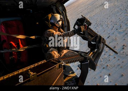 Naval Air Crewman mans a .50-caliber machine gun in an MH-60S Sea Hawk ...