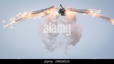 Helicopter deploying flares and chaff- (NH90 military helicopter) a ...