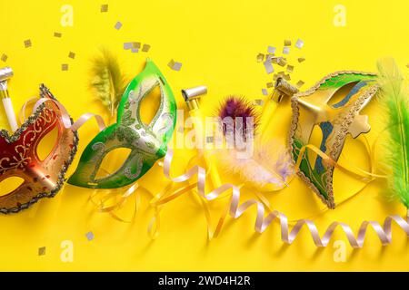 Carnival masks with party horns for Mardi Gras celebration on yellow ...