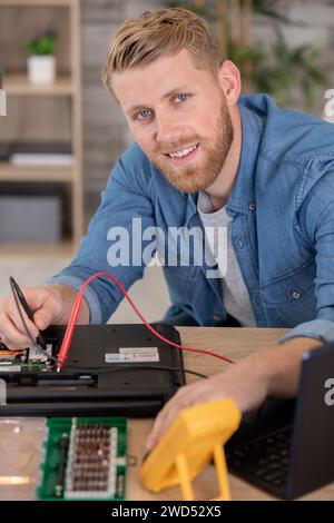 Young man repairing computer hardware in service center Stock Photo - Alamy