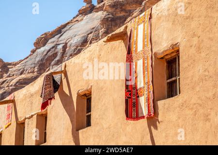 Ornated arabic carpets hanging from the roof of traditional mud houses ...