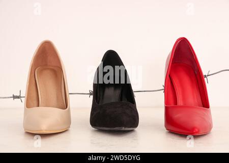 High-heeled shoes with barbed wire on white background. Uncomfortable ...