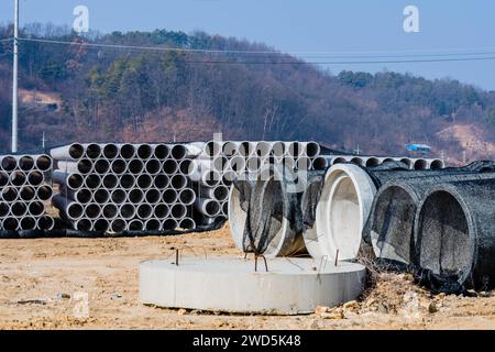 Round concrete culverts covered with black mesh on ground at new ...