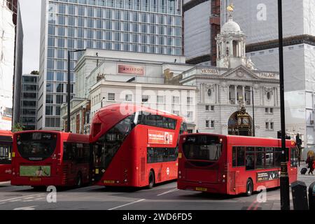 Buses of different shapes and sizes leaving Victoria Station with Victoria Palace Theatre in the ...