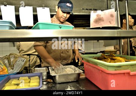 Chefs prepare halal foods at the kitchen of an Islamic cafe managed by ...