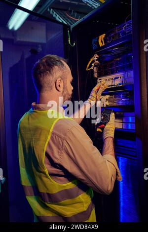 good looking devoted technician in safety clothes working hard holding ...
